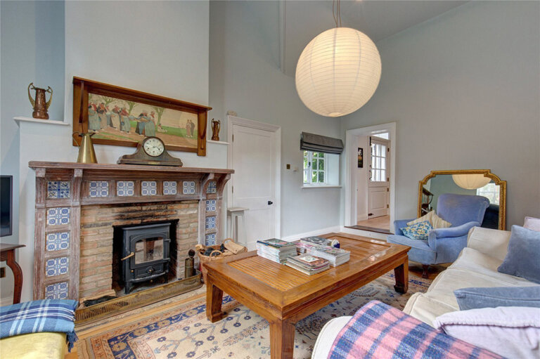 A moated Victorian coach house with clock tower and cottage